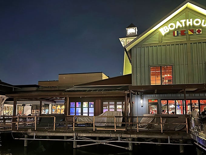 The Boathouse glows like a maritime beacon against the night sky, beckoning hungry travelers with promises of seafood treasures within.
