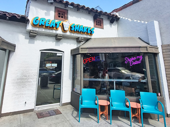 The white stucco exterior promises cool relief from the desert heat, with those bright blue chairs practically begging you to stay awhile.