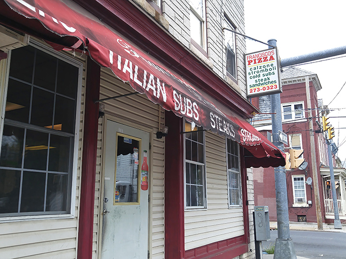 The unassuming storefront of Francisco Pizzeria in Lebanon, PA. Behind that modest red awning lies culinary magic worth traveling for.