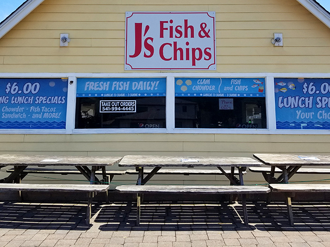 The yellow beacon of seafood salvation! J's Fish & Chips stands out with its cheerful exterior and that quirky robot guardian keeping watch from above.