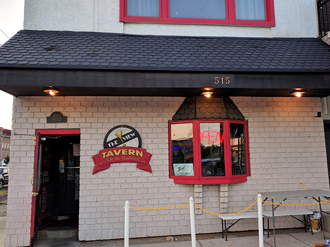 The unassuming brick exterior of The View Tavern, with its charming red trim and white picket fence, proves great food often hides in plain sight.