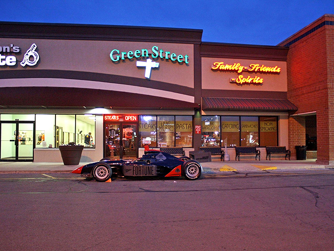 The unassuming exterior of Green Street Pub & Eatery, where culinary magic happens behind that glowing sign. Even race cars make pit stops here!