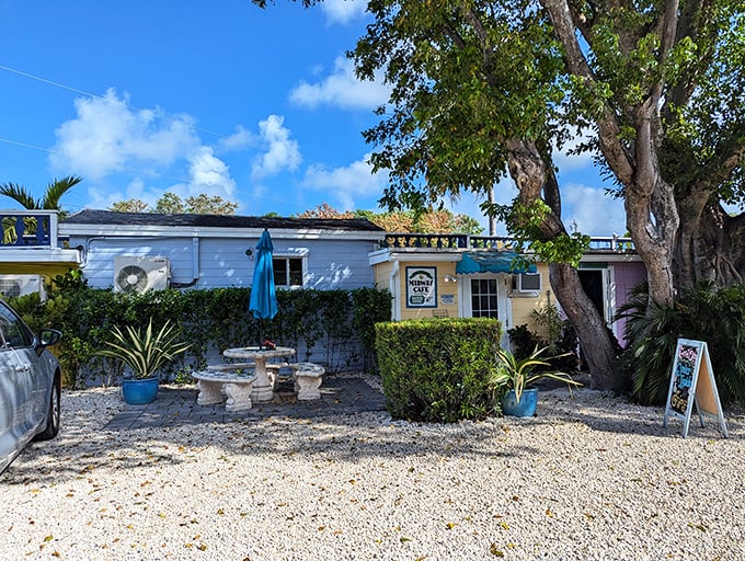 Welcome to paradise! Midway Cafe's unassuming exterior hides culinary treasures behind its weathered charm and inviting stone table setup.