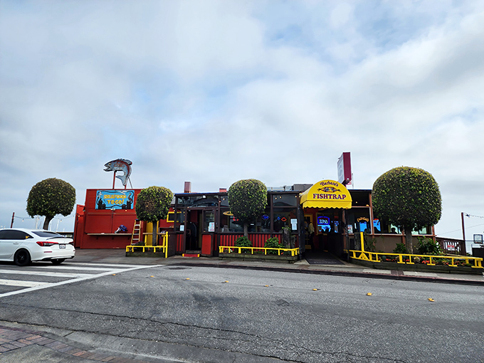 Barbara's Fishtrap stands proudly against the Half Moon Bay sky, its cheerful red exterior and giant crab sculpture announcing: seafood paradise ahead!
