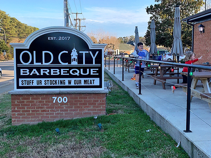 The brick exterior of Old City Barbeque offers a warm welcome, with picnic tables ready for those moments when the Virginia sky demands outdoor dining.