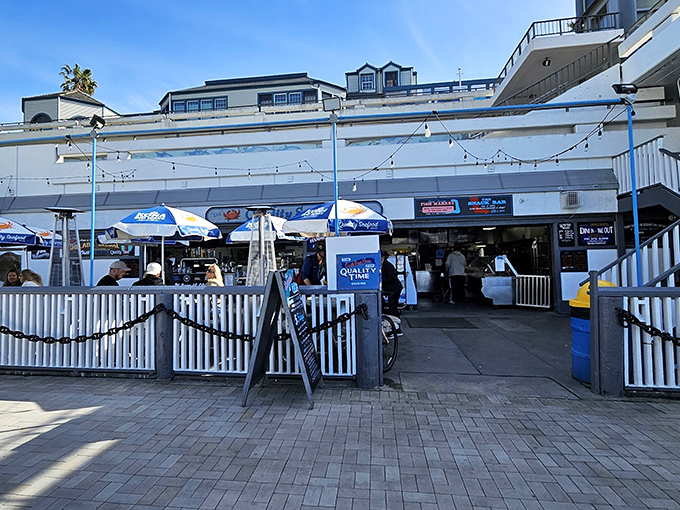 The unassuming entrance to seafood paradise. White picket fences and blue umbrellas welcome you to Quality Seafood, where ocean-to-table isn't a trend&mdash;it's tradition.