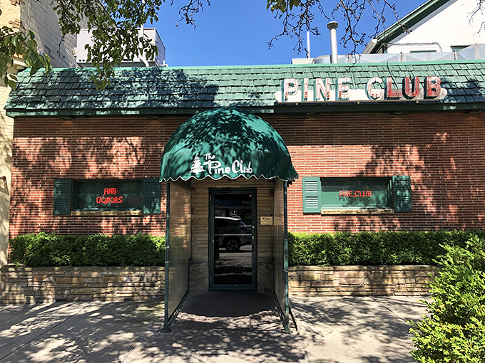The iconic Pine Club exterior beckons with its vintage charm. That green-shingled roof and classic neon sign have been welcoming hungry Daytonians for generations.