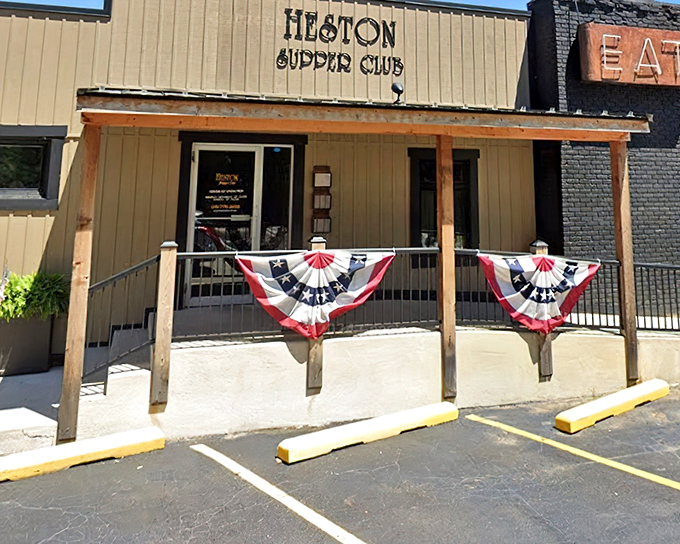 The unassuming exterior of Heston Supper Club, where patriotic bunting and a simple sign promise Midwestern magic within. No flash, all substance.