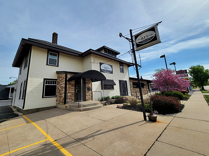 The cream-colored exterior with stone accents and black awnings whispers "classic Wisconsin supper club" without shouting. Culinary treasures await behind that unassuming fa&ccedil;ade.