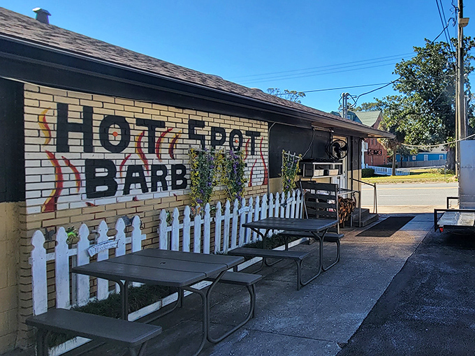 The unassuming yellow brick exterior of Hot Spot Barbecue is like a barbecue speakeasy &ndash; no fancy frills, just a white picket fence guarding smoky treasures within.