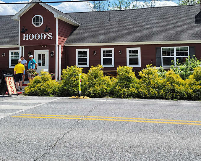 The barn-red exterior of Hood's BBQ welcomes hungry travelers like a beacon of smoky promise. Those hanging flower baskets aren't just for show&mdash;they're saying "slow down and eat something wonderful."