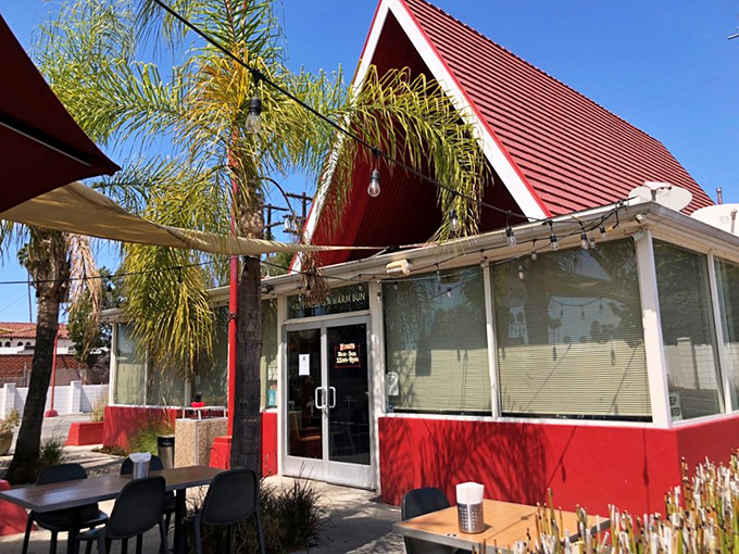 The iconic red A-frame of The Oinkster beckons like a delicious mirage, promising flavor salvation under the California sun. Fast food architecture meets slow food philosophy.