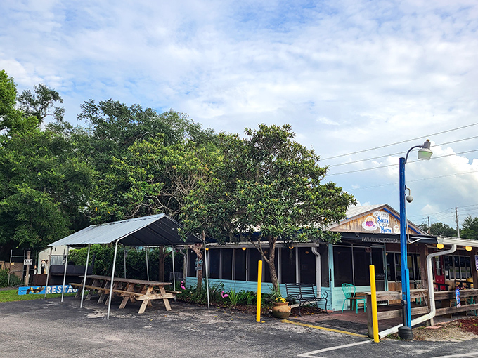 The unassuming exterior of Front Porch Restaurant proves once again that Florida's best culinary treasures often hide in plain sight, nestled under shady trees.