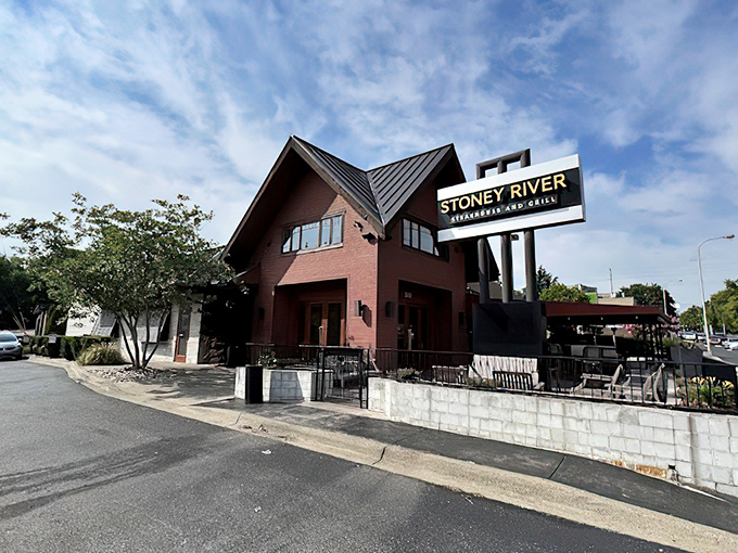 The rustic lodge-inspired exterior of Stoney River stands proudly under the midday sun, promising carnivorous delights within its warm wooden walls.