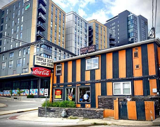 The iconic orange and black striped exterior of Triple XXX stands like a Halloween party that never ended, beckoning hungry travelers with nostalgic charm.