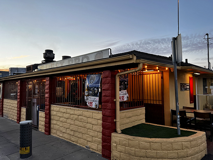 Sunset casts a warm glow on this unassuming barbecue temple, where smoke signals and red walls beckon hungry pilgrims to Santa Paula's meat mecca.