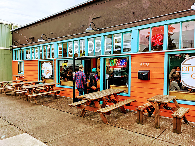 The vibrant orange and teal exterior of Off The Griddle beckons like a tropical oasis in Portland's urban landscape. Those picnic tables have heard some stories.