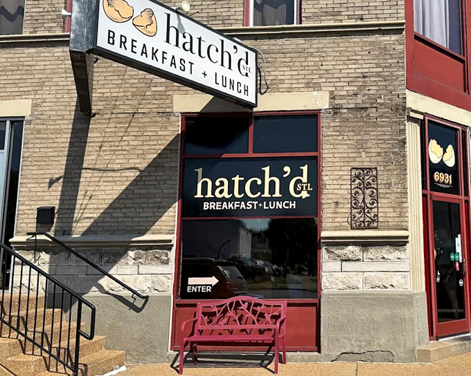 The charming brick exterior of hatch'd STL beckons hungry St. Louis locals with its vintage signage and welcoming red bench&mdash;breakfast paradise found!