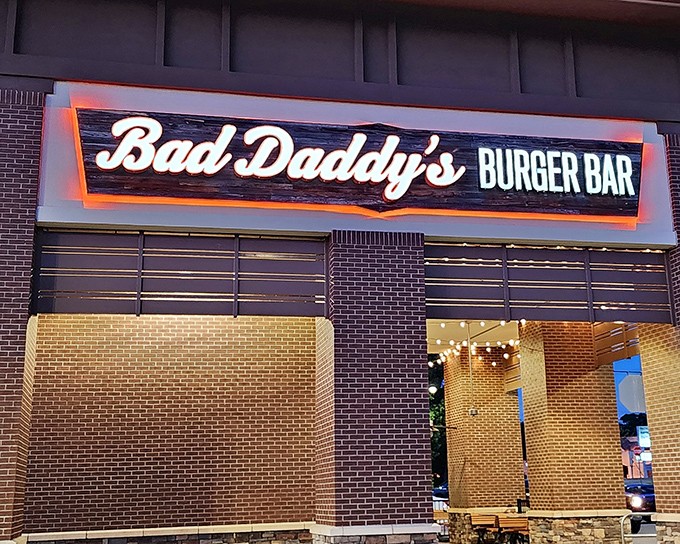 The neon glow of Bad Daddy's sign beckons like a lighthouse for the hungry. This brick-faced burger sanctuary in Greenville promises delicious rebellion in every bite.