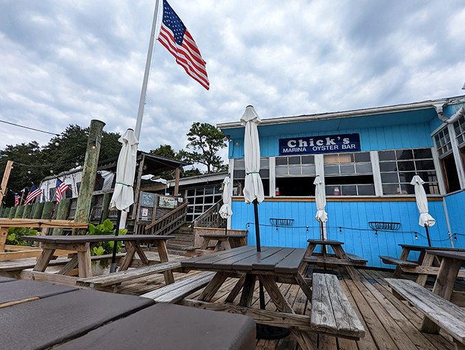The bright blue exterior of Chick's Oyster Bar stands like a cheerful beacon on Lynnhaven Inlet, promising seafood treasures and waterfront relaxation.