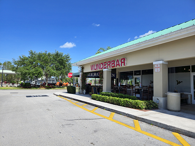 The inviting entrance to Wunderbar beckons with its vibrant blue "BIERGARTEN" sign and climbing vines&mdash;Bavaria's warm embrace in sunny Florida.