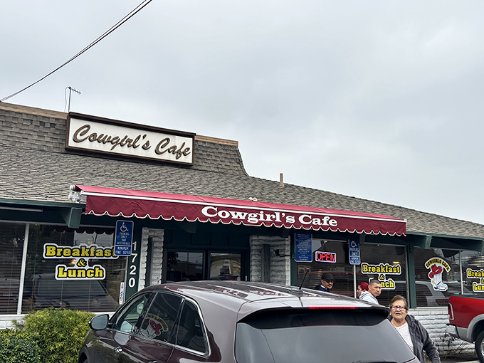 The unassuming exterior of Cowgirls Cafe proves once again that culinary treasures often hide in plain sight. That blue pickup truck knows what's up.