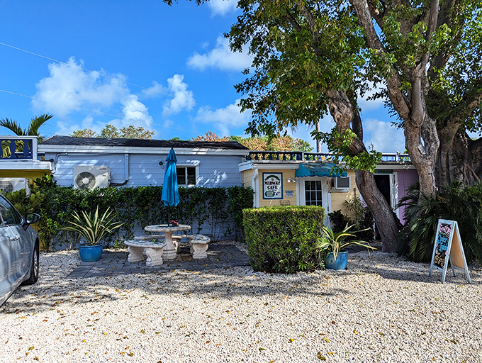 Welcome to paradise! Midway Cafe's unassuming exterior hides culinary treasures behind its weathered charm and inviting stone table setup.