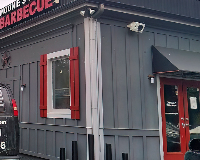 The unassuming gray exterior with punchy red trim is like that quiet friend who suddenly reveals they're a gourmet chef. Barbecue magic happens here.