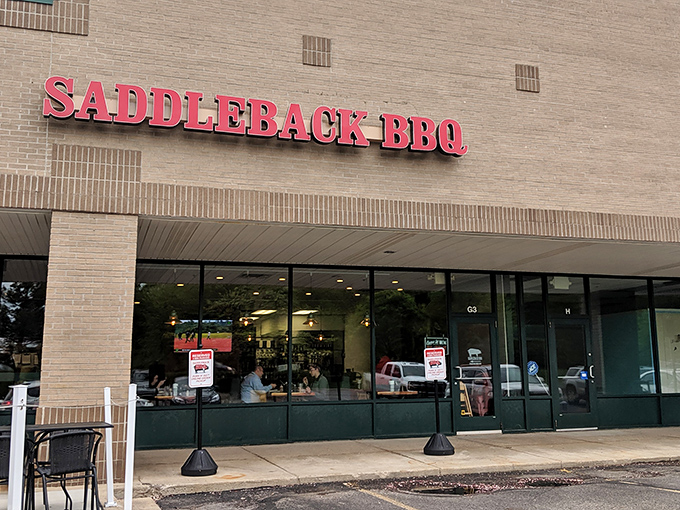 The unassuming storefront hides barbecue greatness like a superhero's secret identity. Red letters promise smoky delights within.