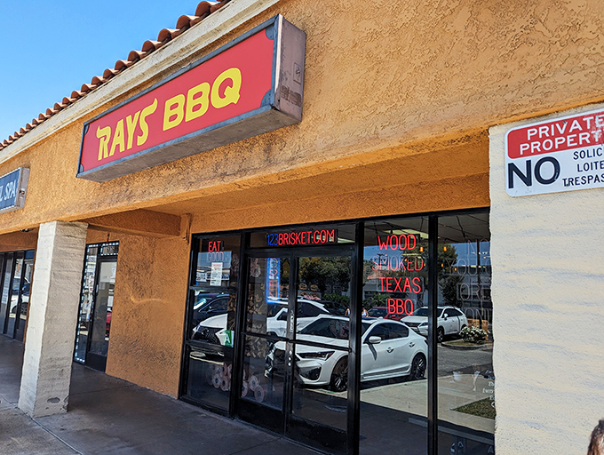 The unassuming stucco exterior of Ray's BBQ might fool you, but that red sign is basically a smoke signal saying "barbecue paradise ahead."