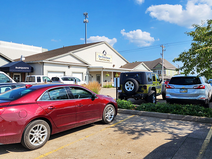 The welcoming facade of Der Dutchman stands like a beacon of comfort food, complete with colorful flower baskets that say "calories don't count in Amish Country."