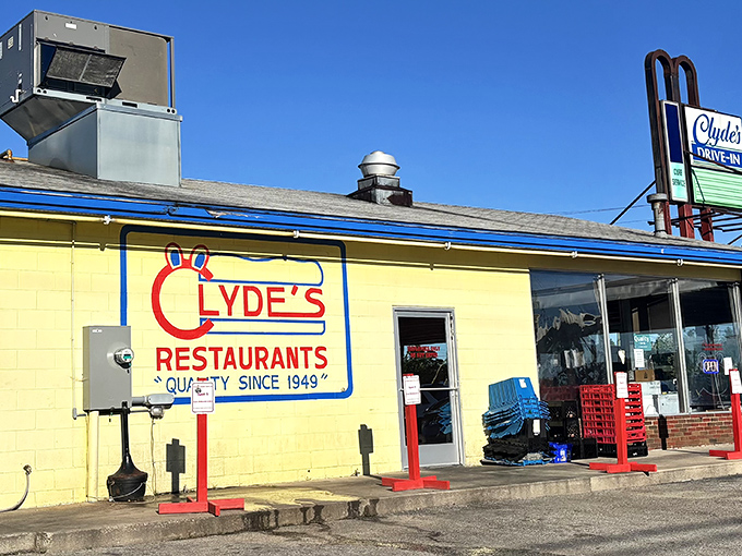 The bright yellow exterior of Clyde's Drive-In stands like a beacon of burger hope against the Michigan sky, promising delicious nostalgia with every visit.