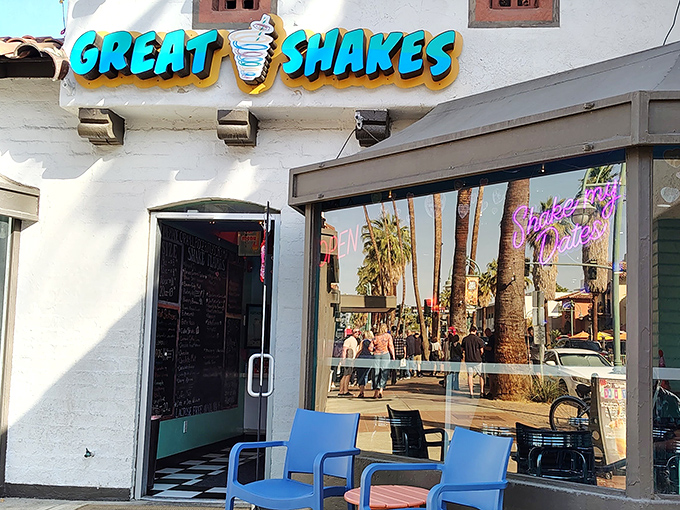 The white stucco exterior promises cool relief from the desert heat, with those bright blue chairs practically begging you to stay awhile.