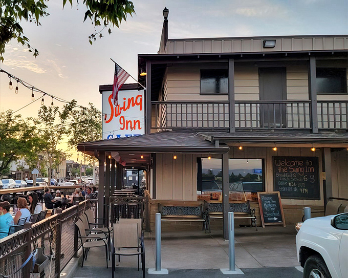 The iconic Swing Inn sign glows like a beacon at dusk, promising comfort food salvation to weary travelers and locals alike.