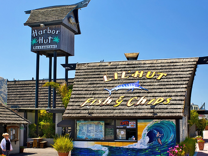 The A-frame wonder of Harbor Hut stands proudly against the California sky, its wave mural promising seafood adventures within.