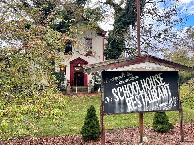 The white schoolhouse with its distinctive red trim stands like a time capsule among autumn trees, inviting hungry students of good food to come inside.