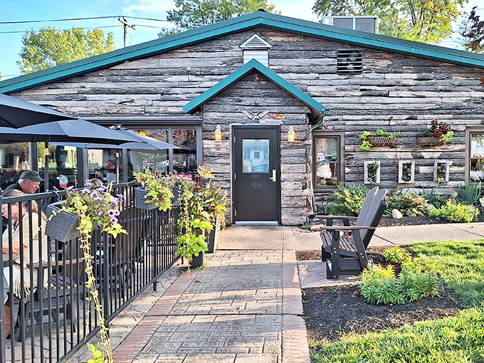 The weathered log cabin exterior of The Whitehouse Inn beckons like a rustic time machine, promising comfort food treasures behind that unassuming wooden facade.