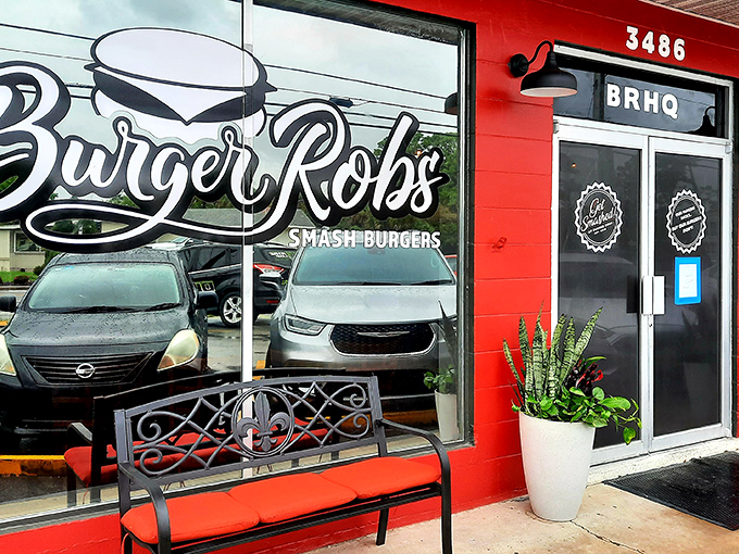 The bright red exterior of BurgerRobs beckons like a burger lighthouse, complete with a welcoming bench for those who can't wait to dig in.