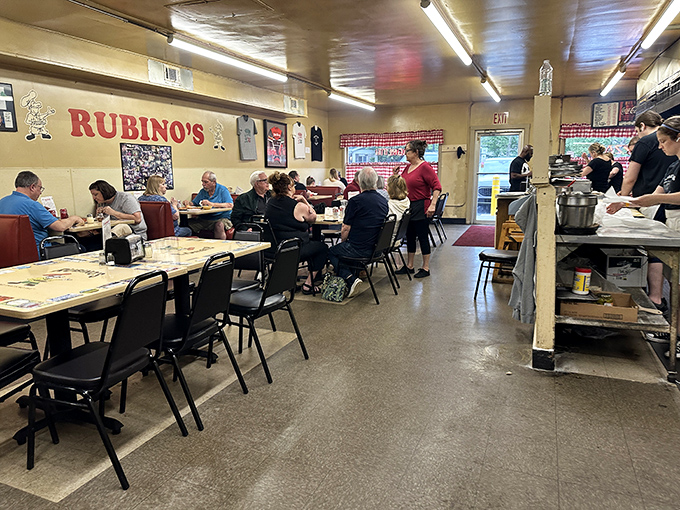 The unassuming brick exterior of Rubino's Pizza, with those iconic red-checkered curtains, is like finding a secret doorway to pizza paradise.