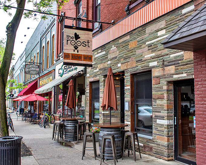 The charming stone facade of The Roost beckons from Wellsboro's picturesque Main Street, where barrel tables invite passersby to linger over craft brews and conversation.