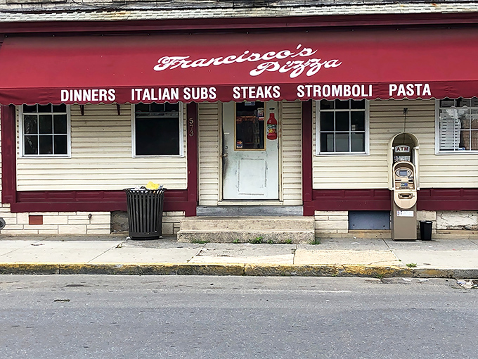 The unassuming storefront of Francisco Pizzeria in Lebanon, PA. Behind that modest red awning lies culinary magic worth traveling for.