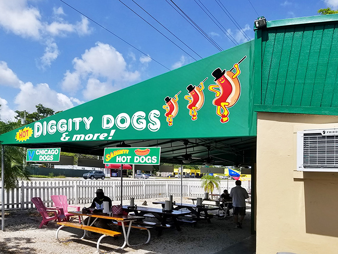 The iconic green awning of Hot Diggity Dogs beckons like a beacon of hope for the hungry. Simple picnic tables promise no pretense&mdash;just delicious satisfaction ahead.
