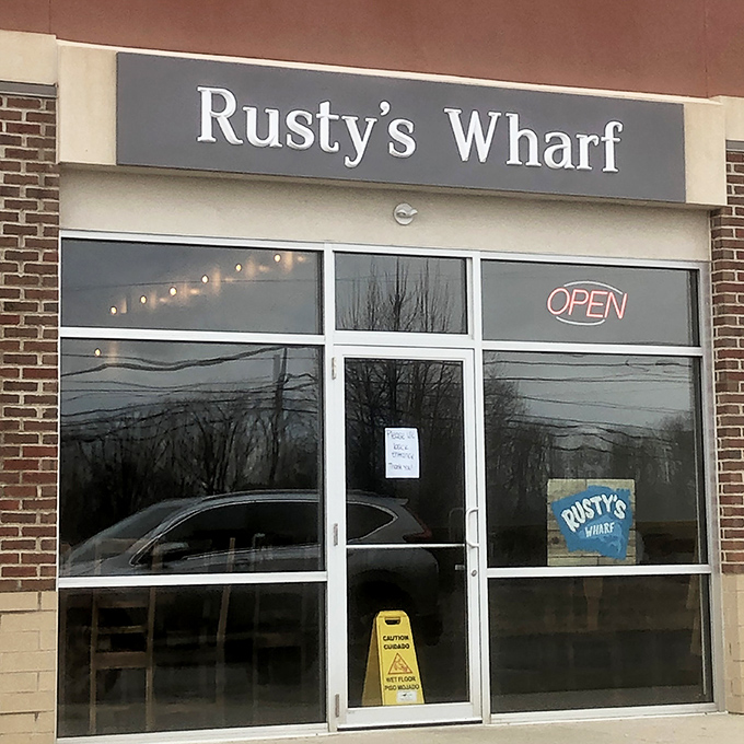 Rusty's Wharf glows like a maritime beacon in suburban Ohio, its bright yellow walls and neon "OPEN" sign promising seafood salvation to landlocked locals.