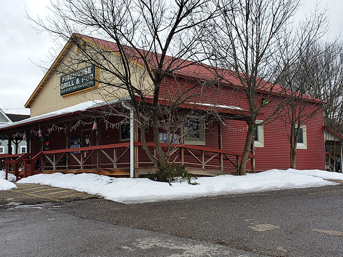 The distinctive red exterior of Rootstown Firehouse Grille & Pub welcomes visitors with its charming wraparound porch and cozy small-town appeal.
