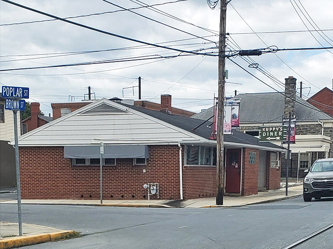 The unassuming brick exterior of Kuppy's Diner might not scream "culinary destination," but that red door is practically a portal to breakfast nirvana.