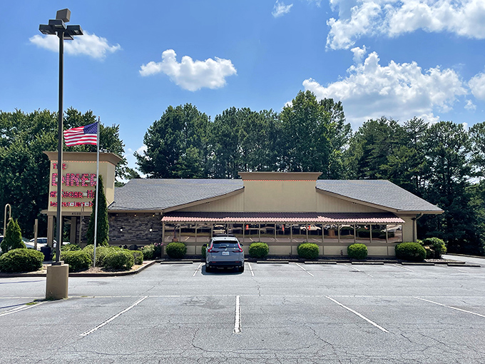 The classic stone facade and iconic red sign of The Diner at Sugar Hill promise comfort food paradise beneath the Georgia sky.