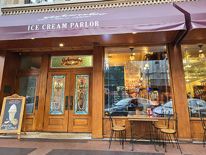 The entrance to Zaharakos beckons like a portal to another era, with stained glass windows and wooden doors that have welcomed ice cream lovers since 1900.