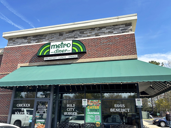 Metro Diner's inviting exterior beckons with its signature green awning and warm brick facade. Like a lighthouse for the hungry, it promises comfort in every bite.
