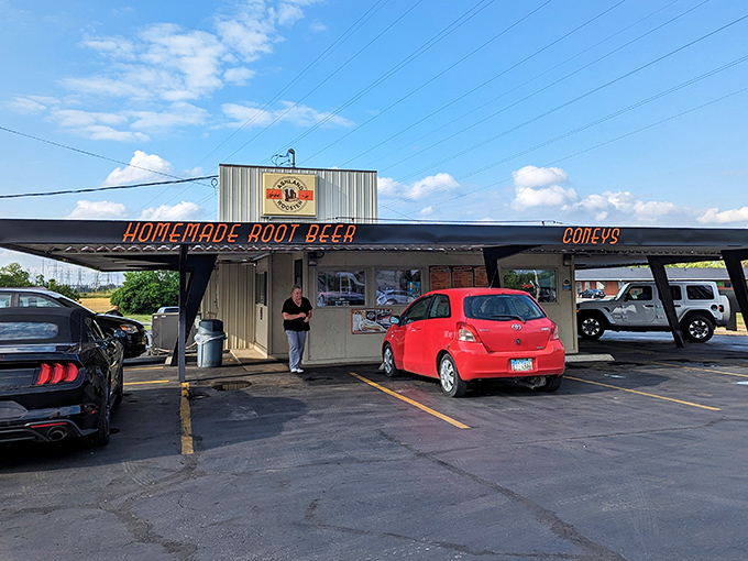 The unassuming exterior of Ashland-Wooster Drive-In stands as a time capsule of Americana, where that neon "HOMEMADE ROOT BEER" sign promises liquid gold awaits.