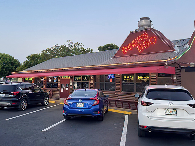 The neon glow of Shiver's BBQ sign is like a smoky lighthouse guiding hungry souls to barbecue paradise. No fancy frills, just the promise of meaty delights within.